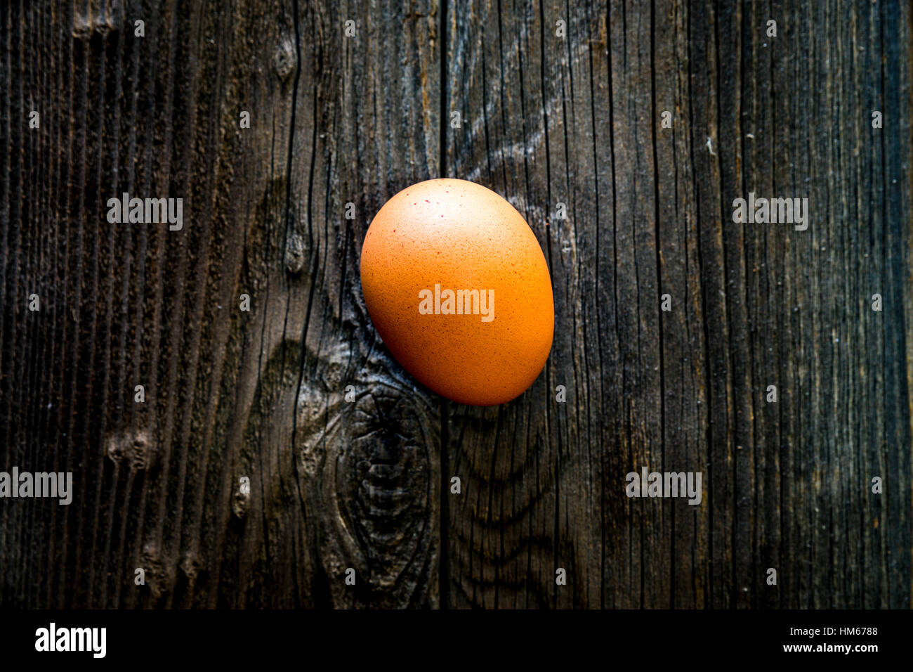 A single egg on a rustic wooden table Stock Photo - Alamy