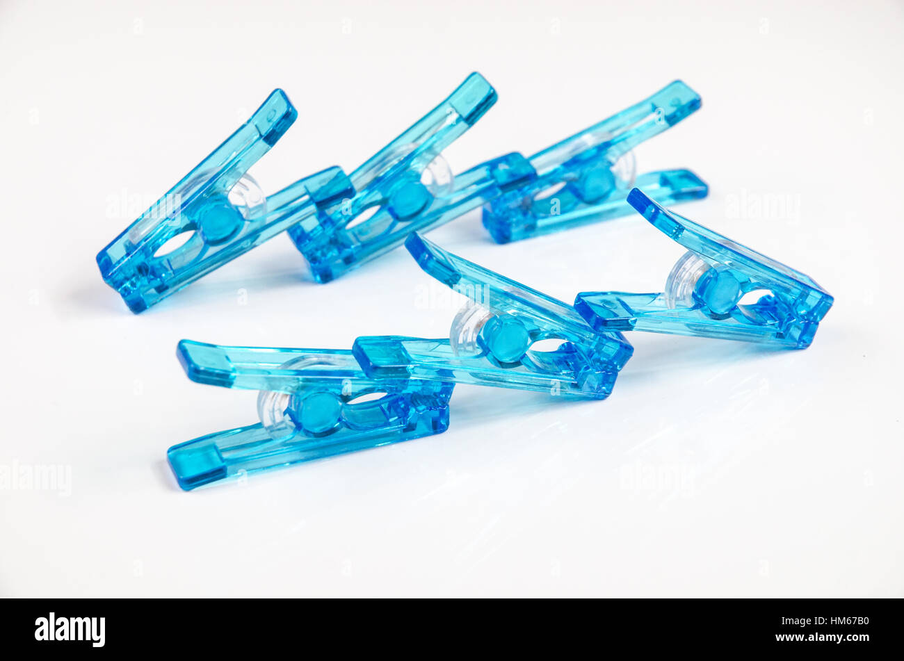 Blue plastic clothespins on white background Stock Photo - Alamy