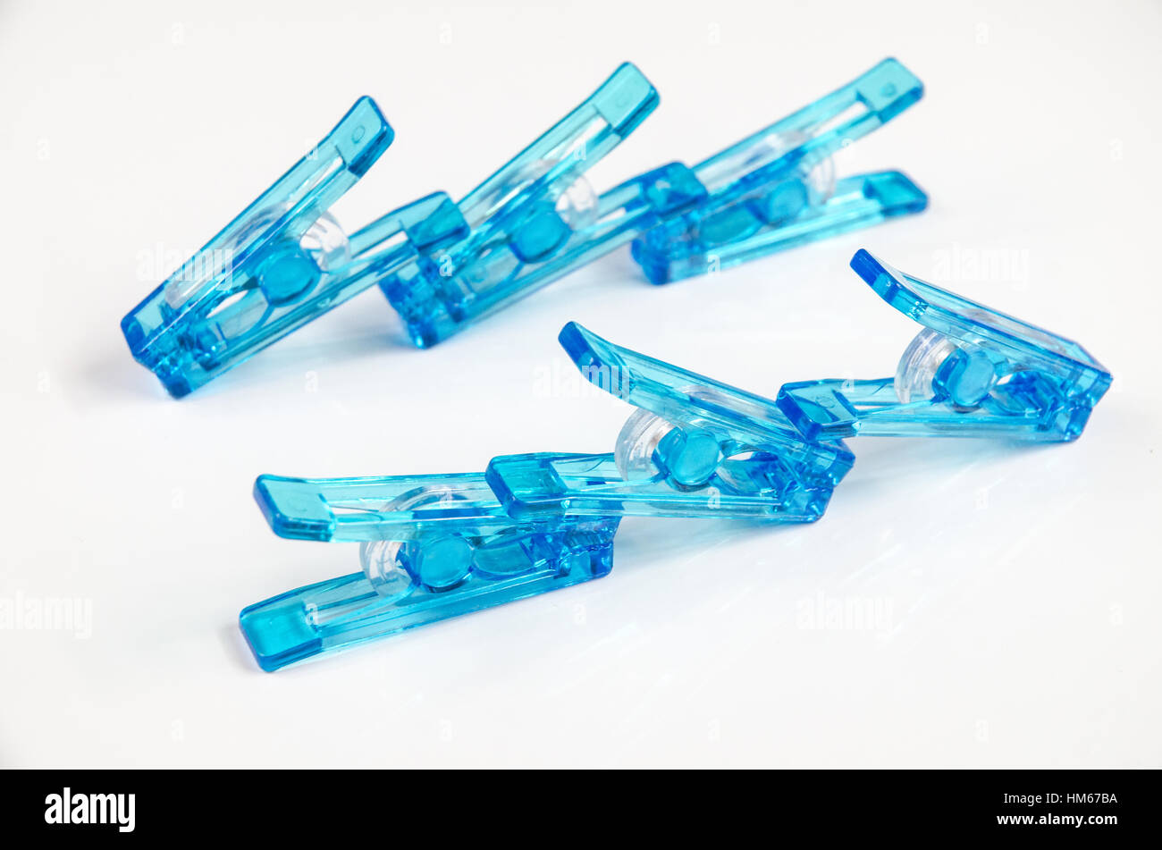 Blue plastic clothespins on white background Stock Photo - Alamy