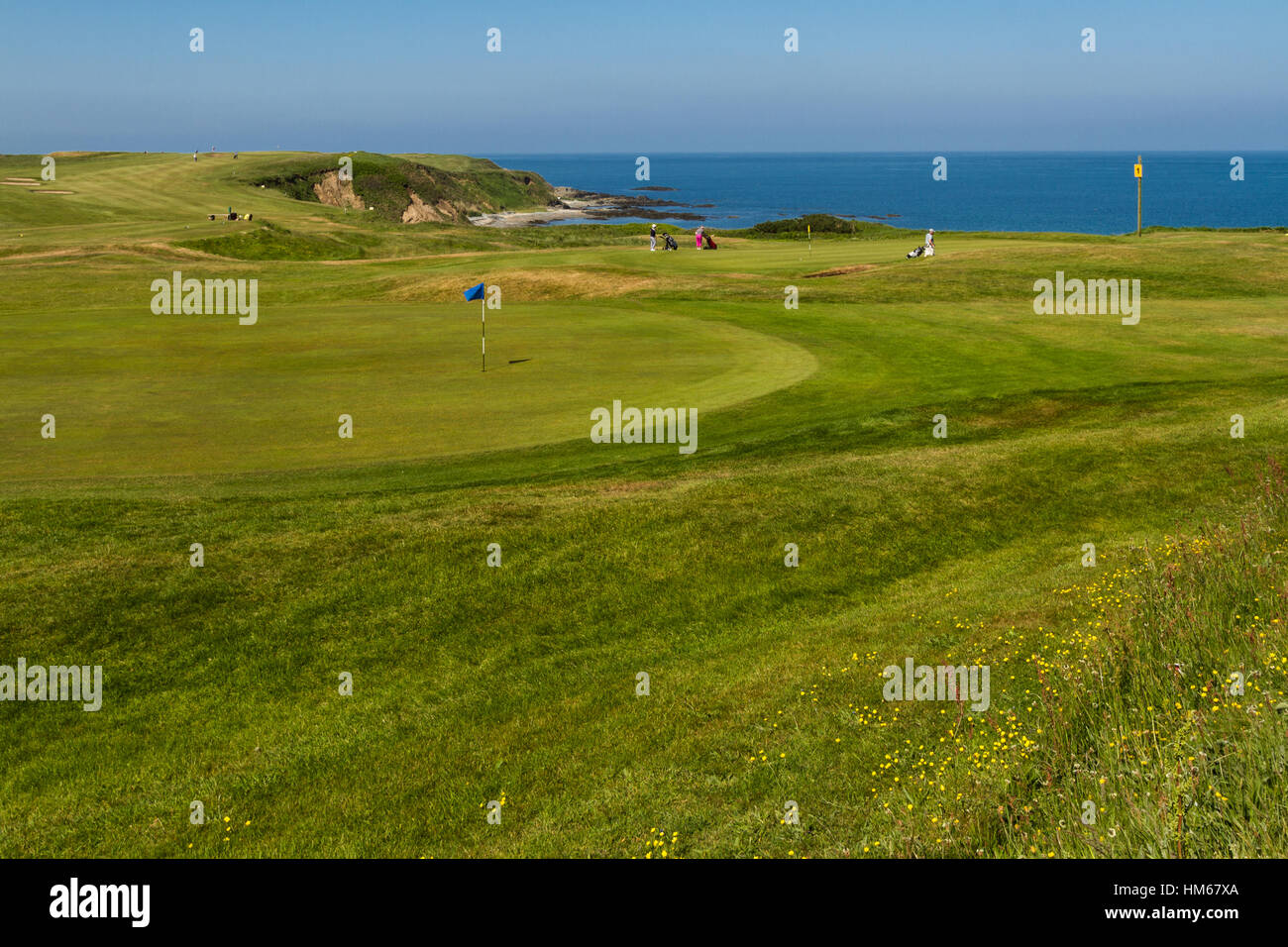 MORFA NEFYN – JUNE 3: Golf course putting green with golfers, sea in ...