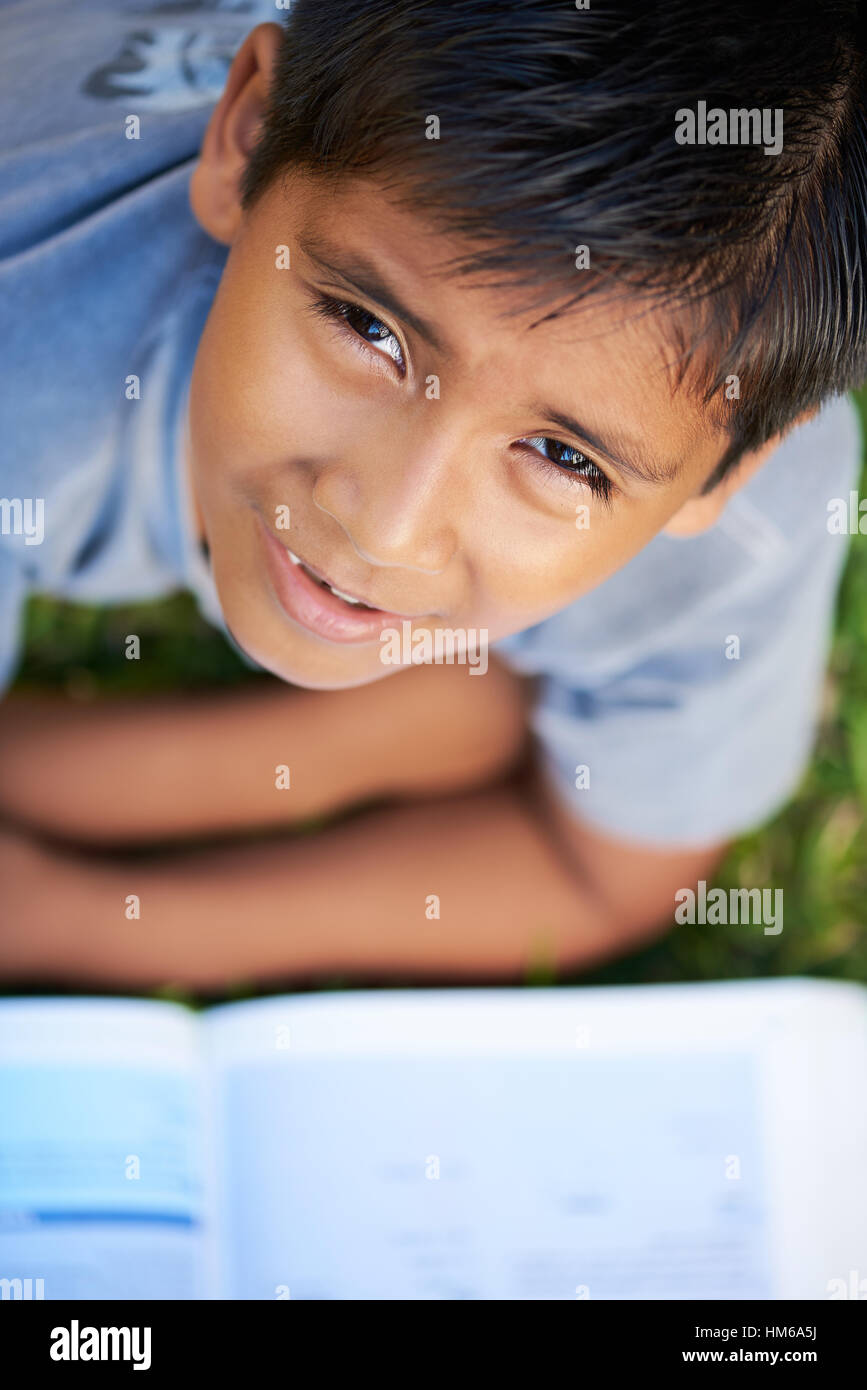boy studying by book on green grass Stock Photo - Alamy