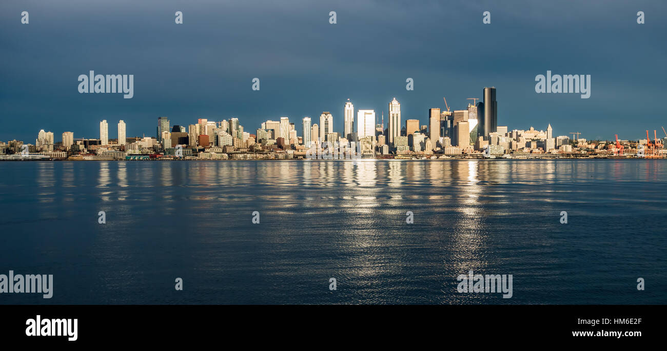 As the sun sets the buildings of the Seattle skyline are reflected in ...