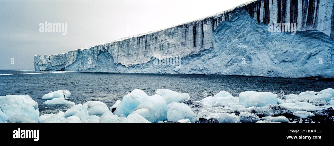 Ice boulders gather along a beach after falling from the fracture zone ...