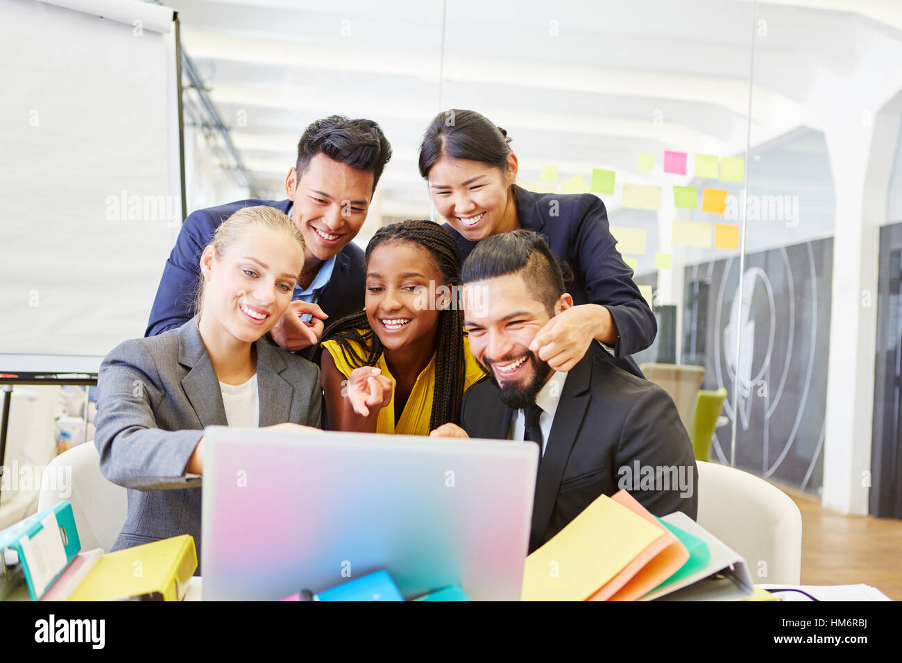 Business people having fun with computer in workshop Stock Photo - Alamy
