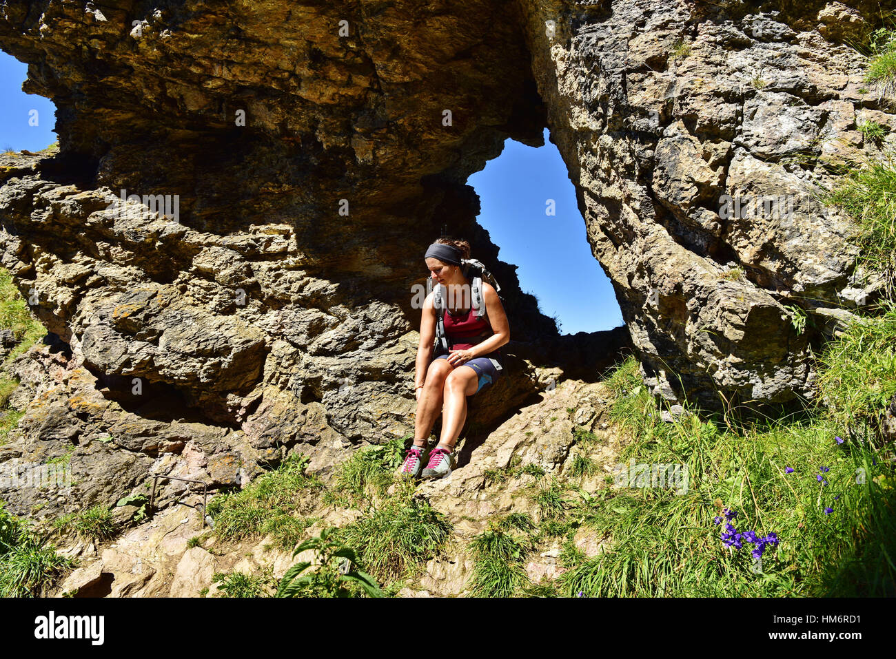 young woman sitting at natural arch Stock Photo - Alamy