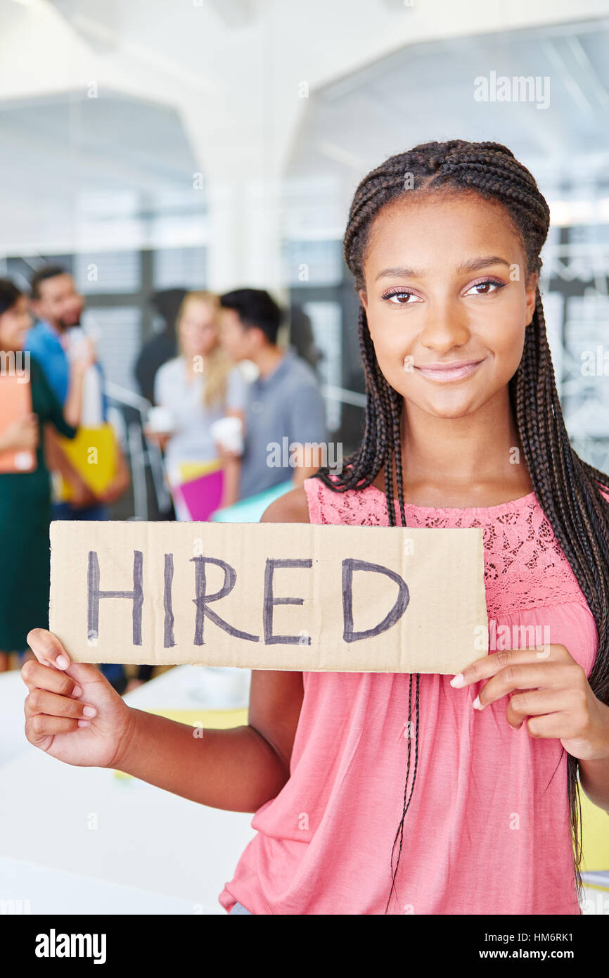 Young african business woman as trainee in start-up holding "hired ...