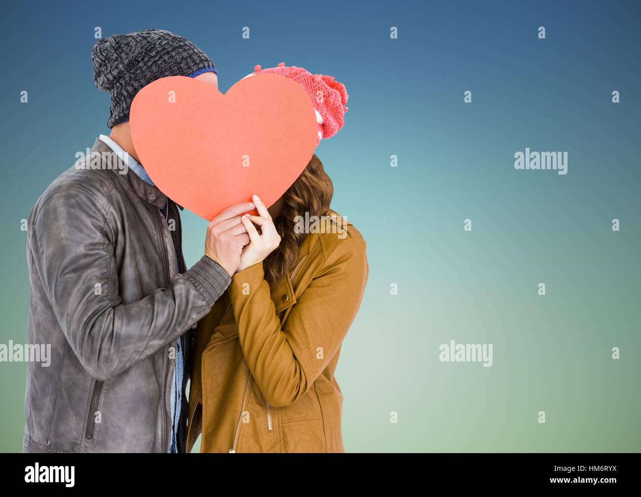 Romantic couple hiding their face behind heart Stock Photo - Alamy
