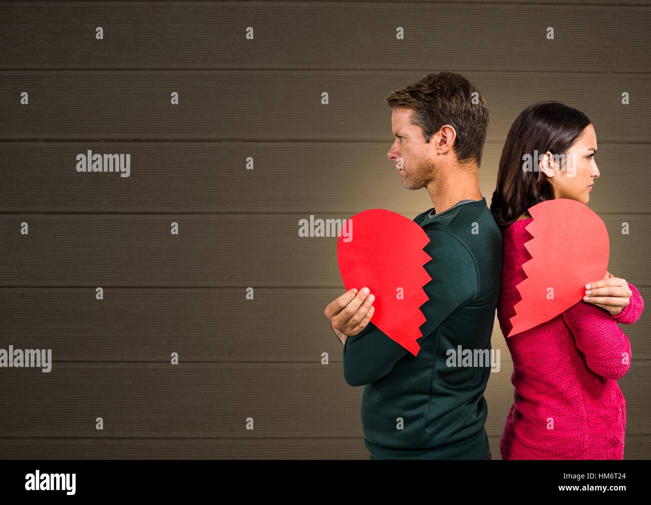 Angry couple holding broken heart Stock Photo - Alamy