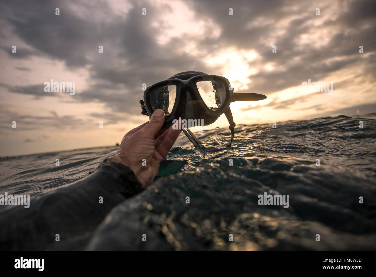 Cropped image of hand holding swimming goggles in sea Stock Photo - Alamy
