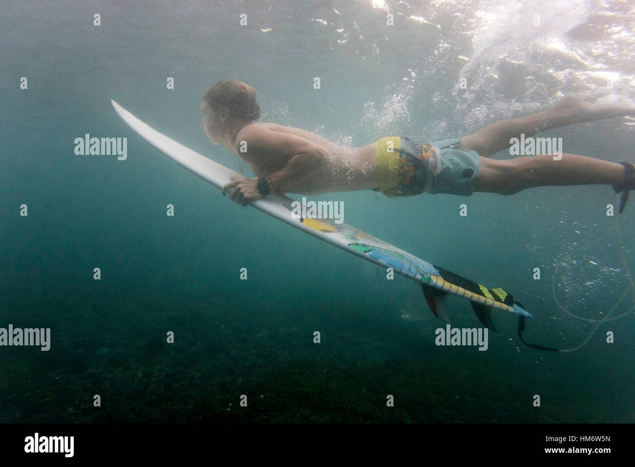 Side view of man surfboarding underwater Stock Photo - Alamy