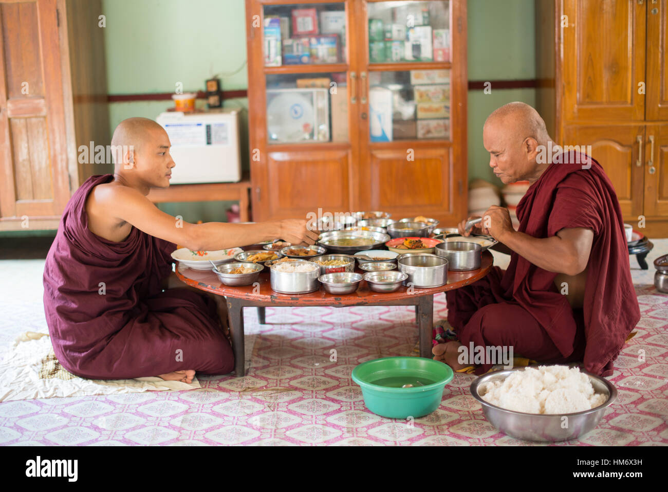 BAGAN, Myanmar - Two monks eating a midday meal at a Monastery in Bagan ...
