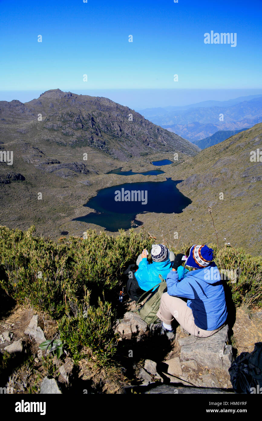 Tourists looking at Lake Chirripo from the summit of Mount Chirripo ...