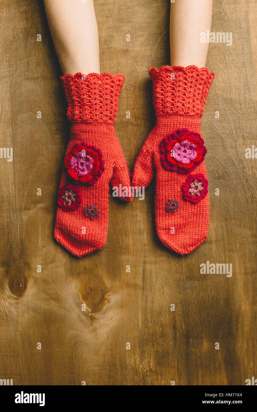 The red mittens placed on wooden background. Girl’s hands in red ...