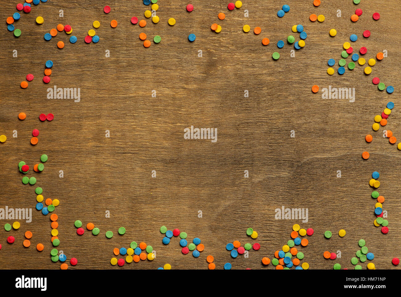 Confetti scattered on a wooden table and create happy party background ...