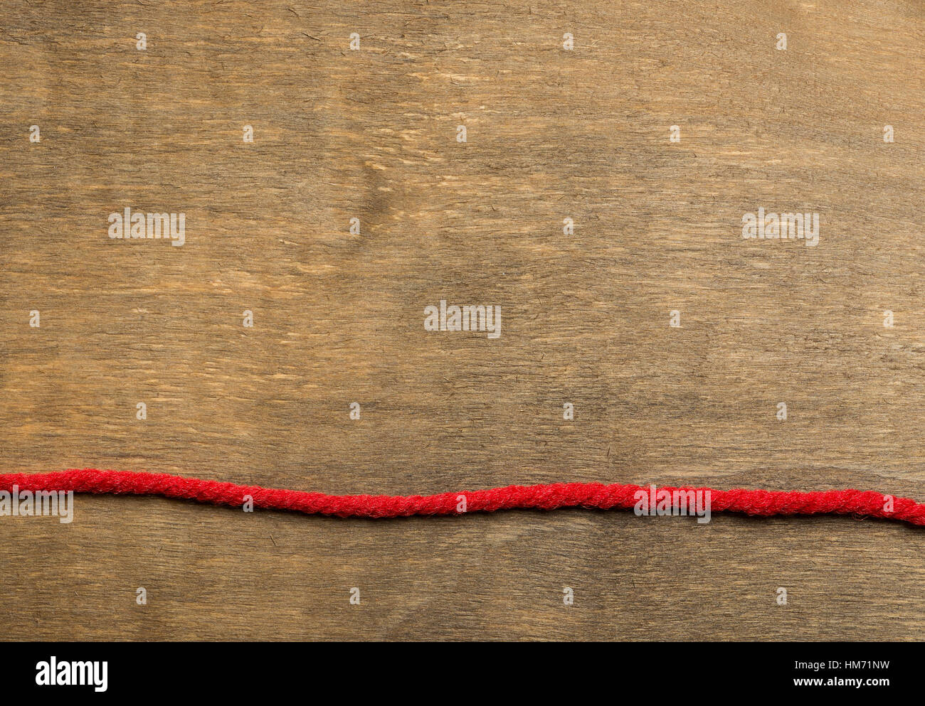 The red thread above vintage wooden background in the lower part of ...