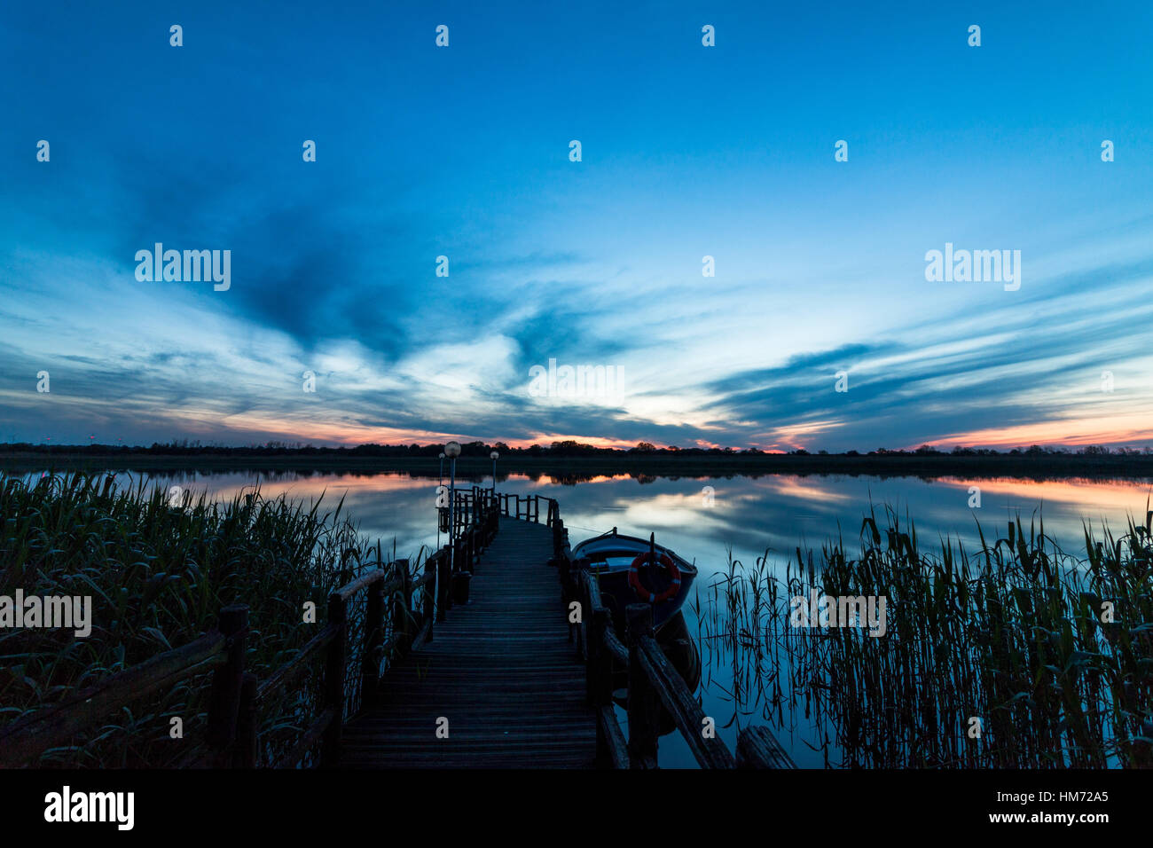 Beautiful sunset at the small dock in "Shabla Lake". Epic clouds and ...