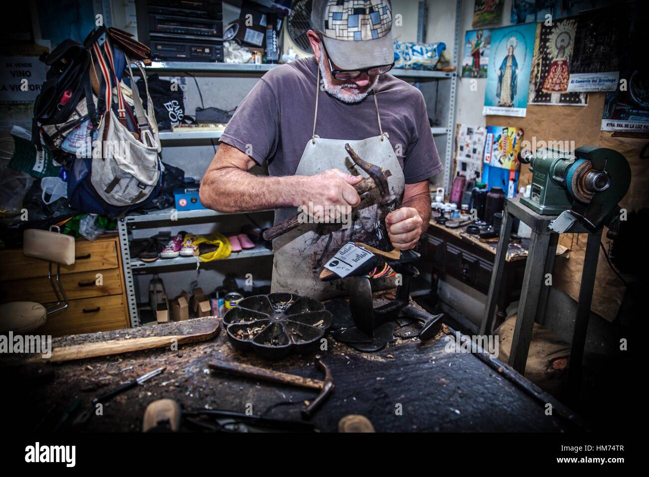adult male shoemender working at his own workshop Stock Photo - Alamy
