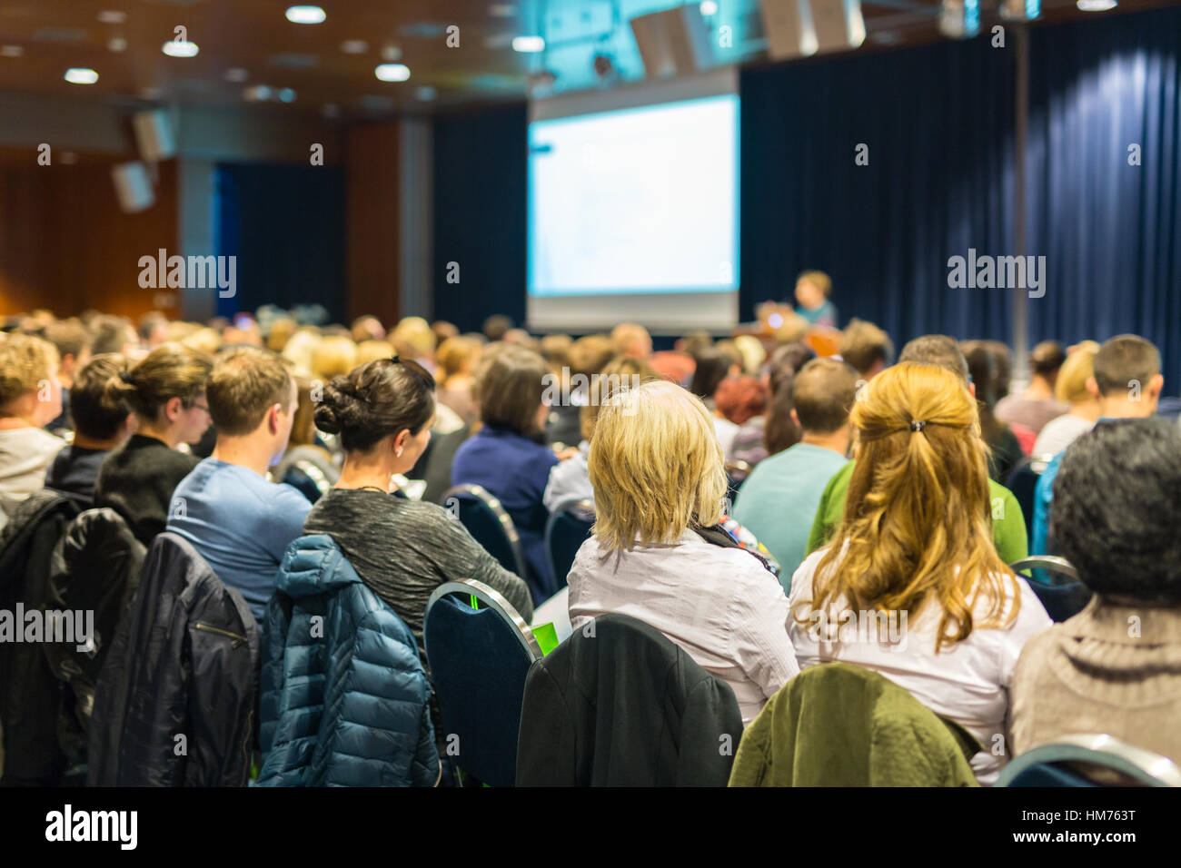 Audience in lecture hall participating at business event Stock Photo ...