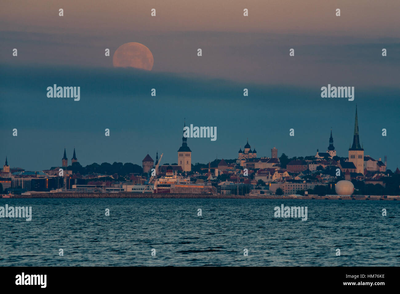 Full moon over Old town of Tallinn city, Estonia. Moonset before ...