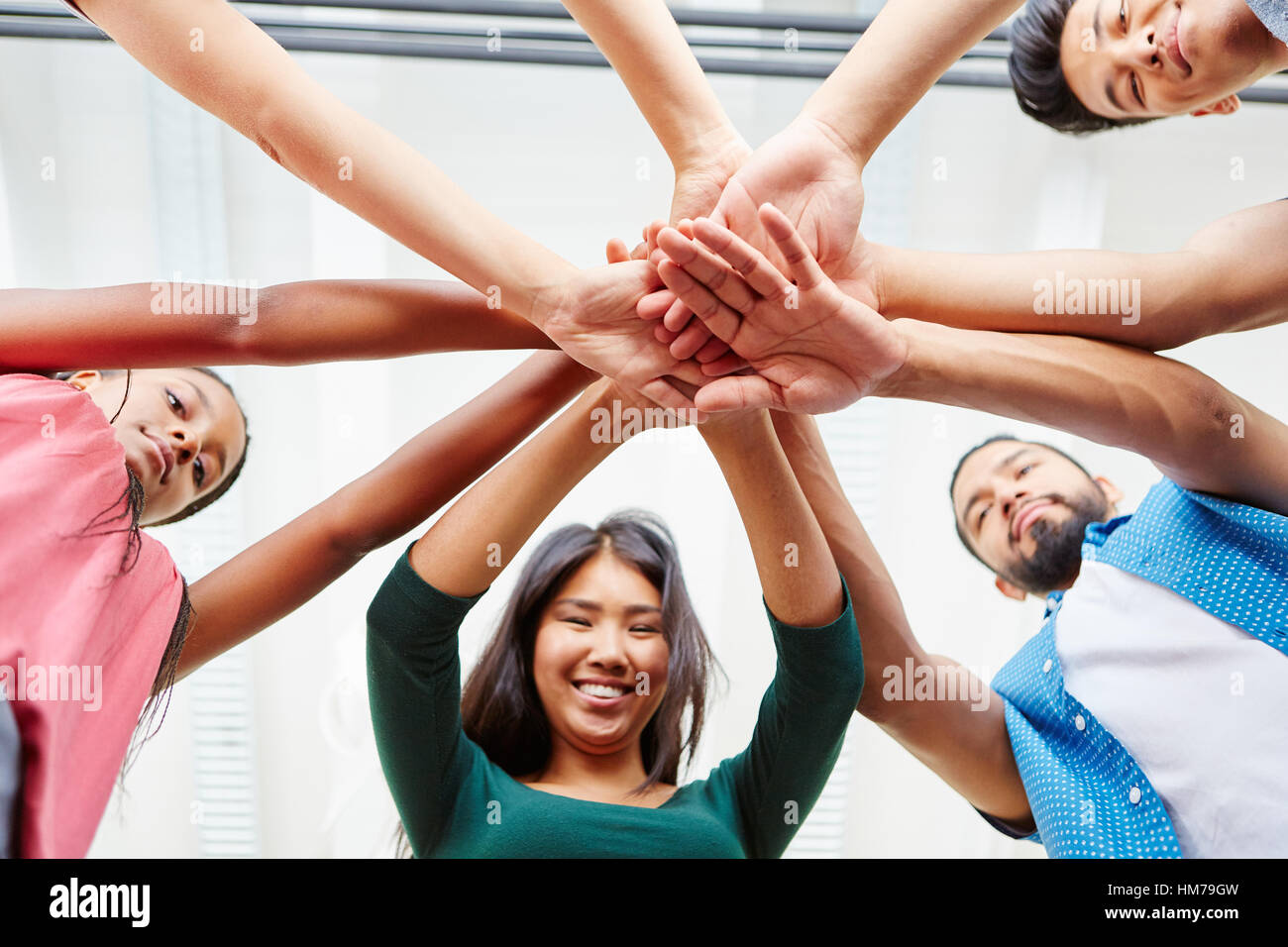 Stacked hands forming network between team members Stock Photo - Alamy