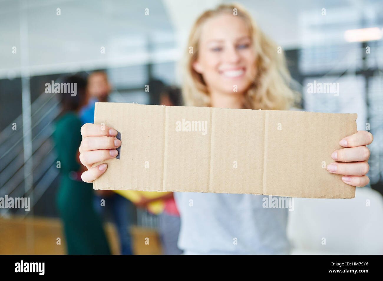Happy trainee holding blank sign for business message Stock Photo - Alamy