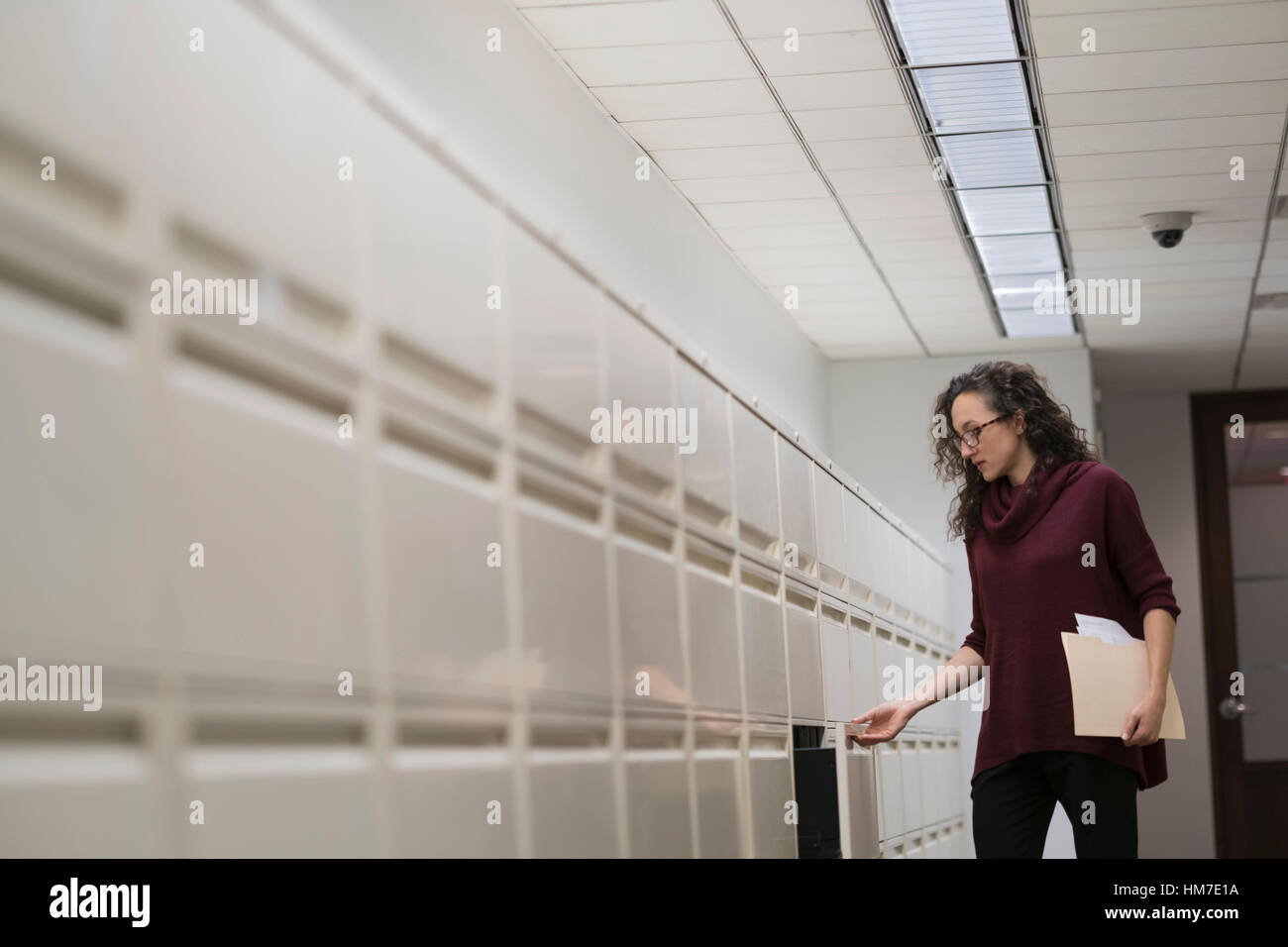 Young woman opening drawer in corridor Stock Photo - Alamy