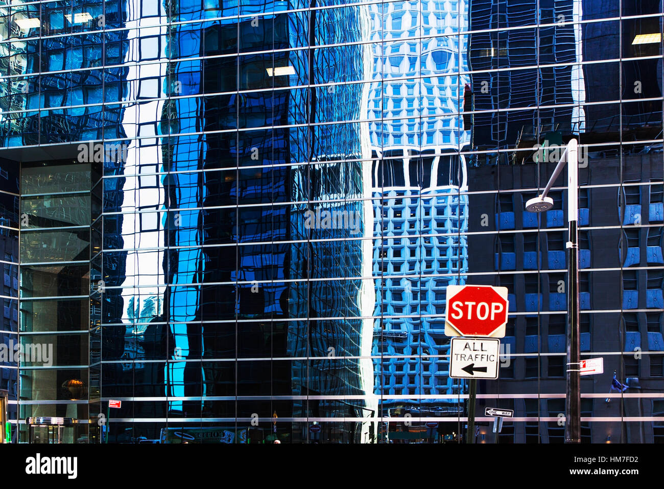 USA, New York, Distorted reflections in office building and stop sign ...