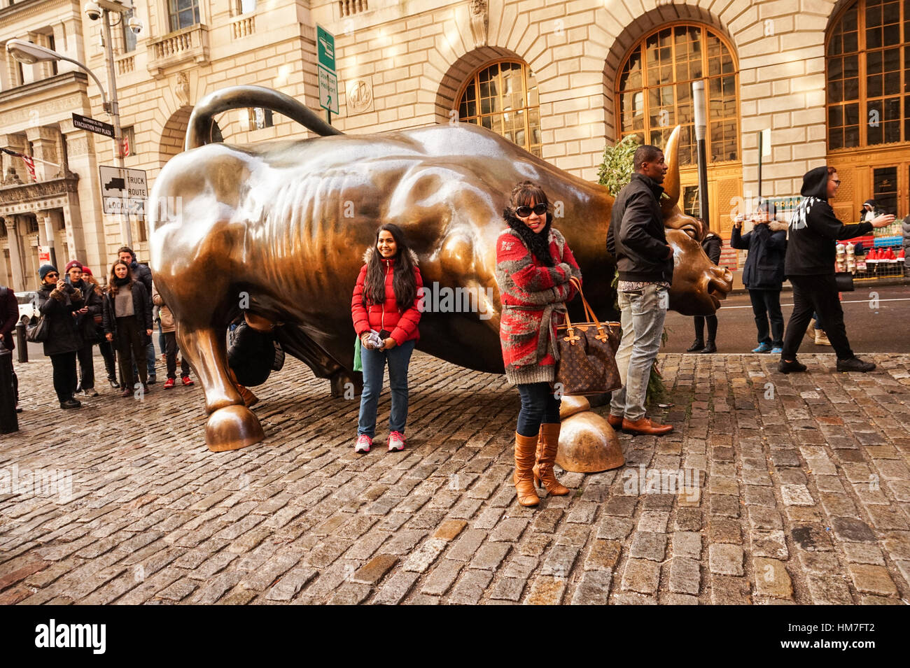 Tourists taking photos with the Charging Bull sculpture in a Christmas ...