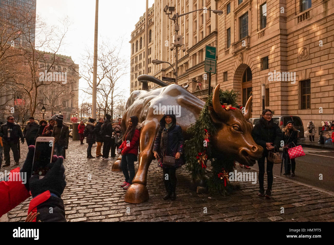 Tourists taking photos with the Charging Bull sculpture in a Christmas ...