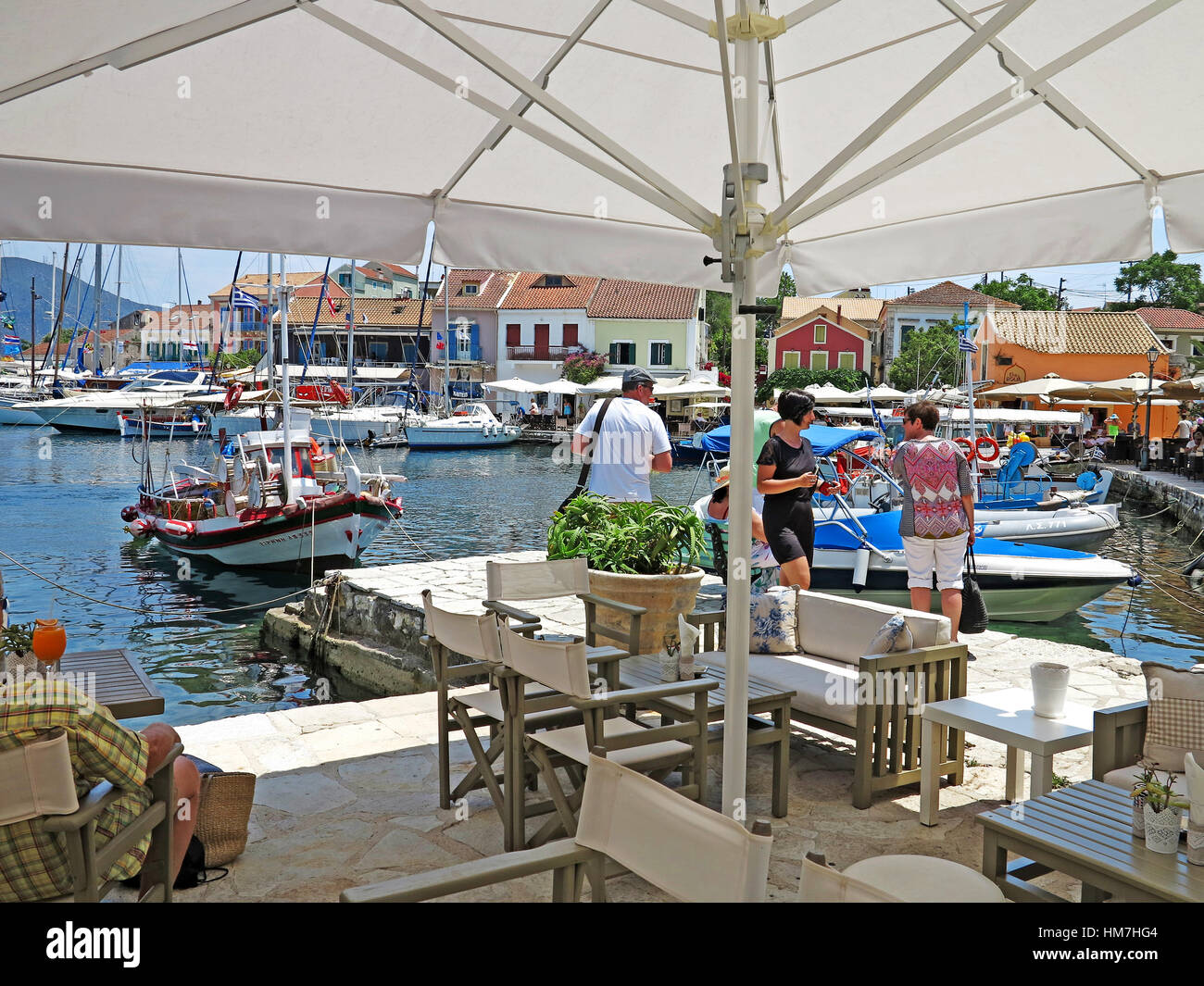 Seafront restaurant from under parasol of fishing boats and yachts ...