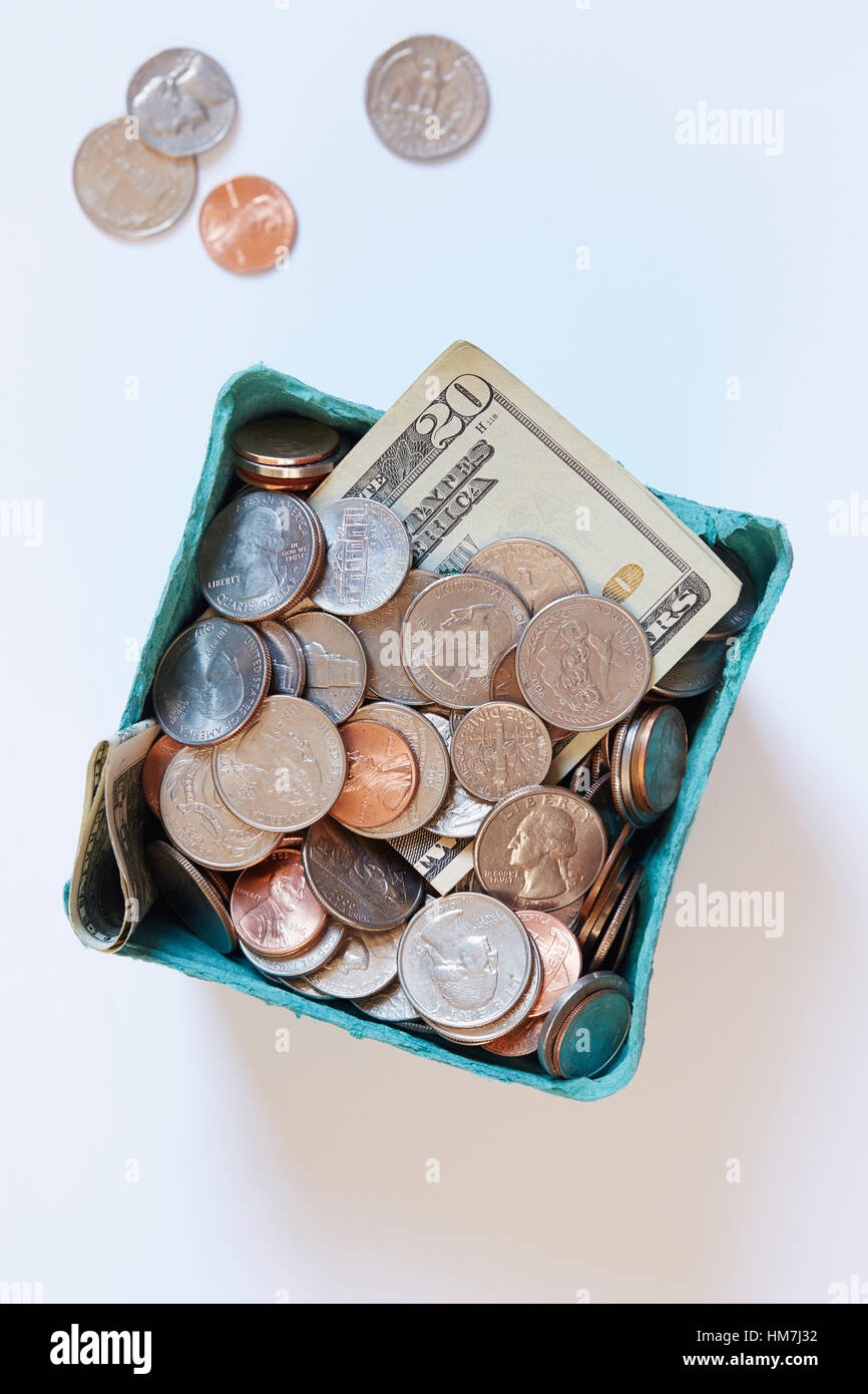 Coins and banknotes in carton box on white surface Stock Photo - Alamy