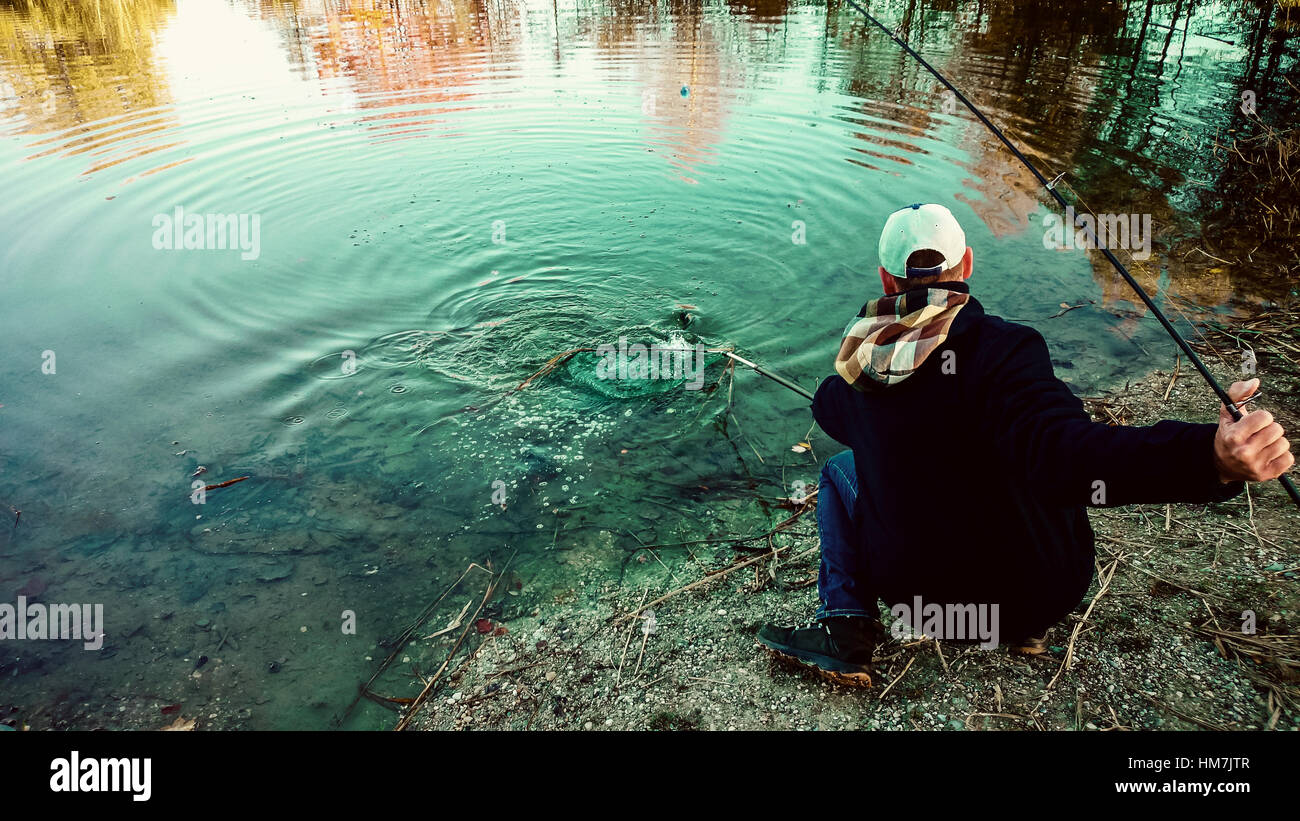 Fisherman with fishing rod and landing net during pulling out Stock ...