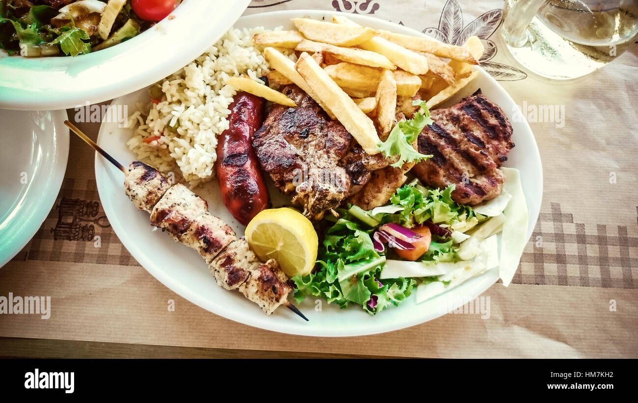 Mix meat plate with french fries, Greek food Stock Photo - Alamy