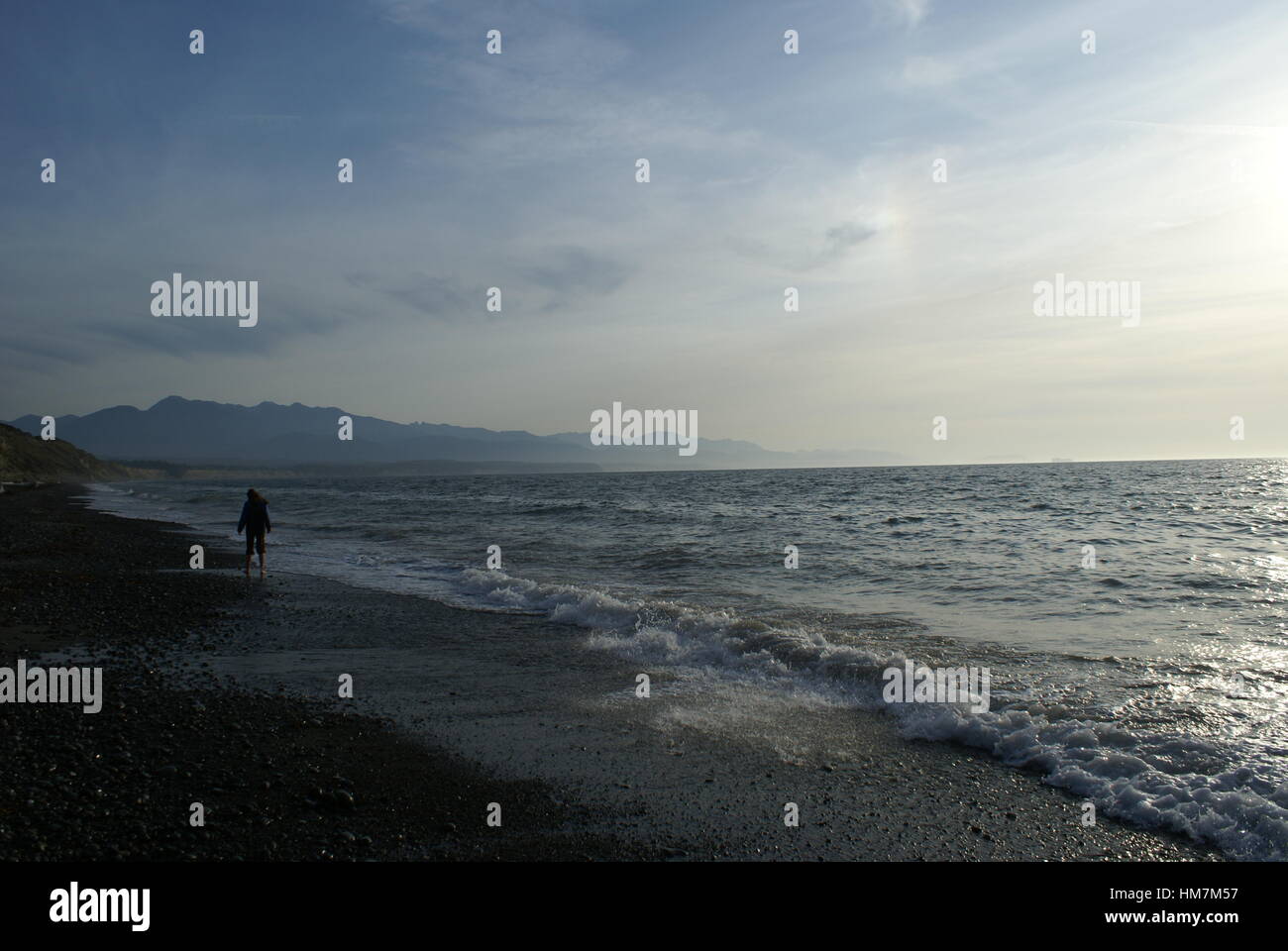 Single person walking on the beach Stock Photo - Alamy
