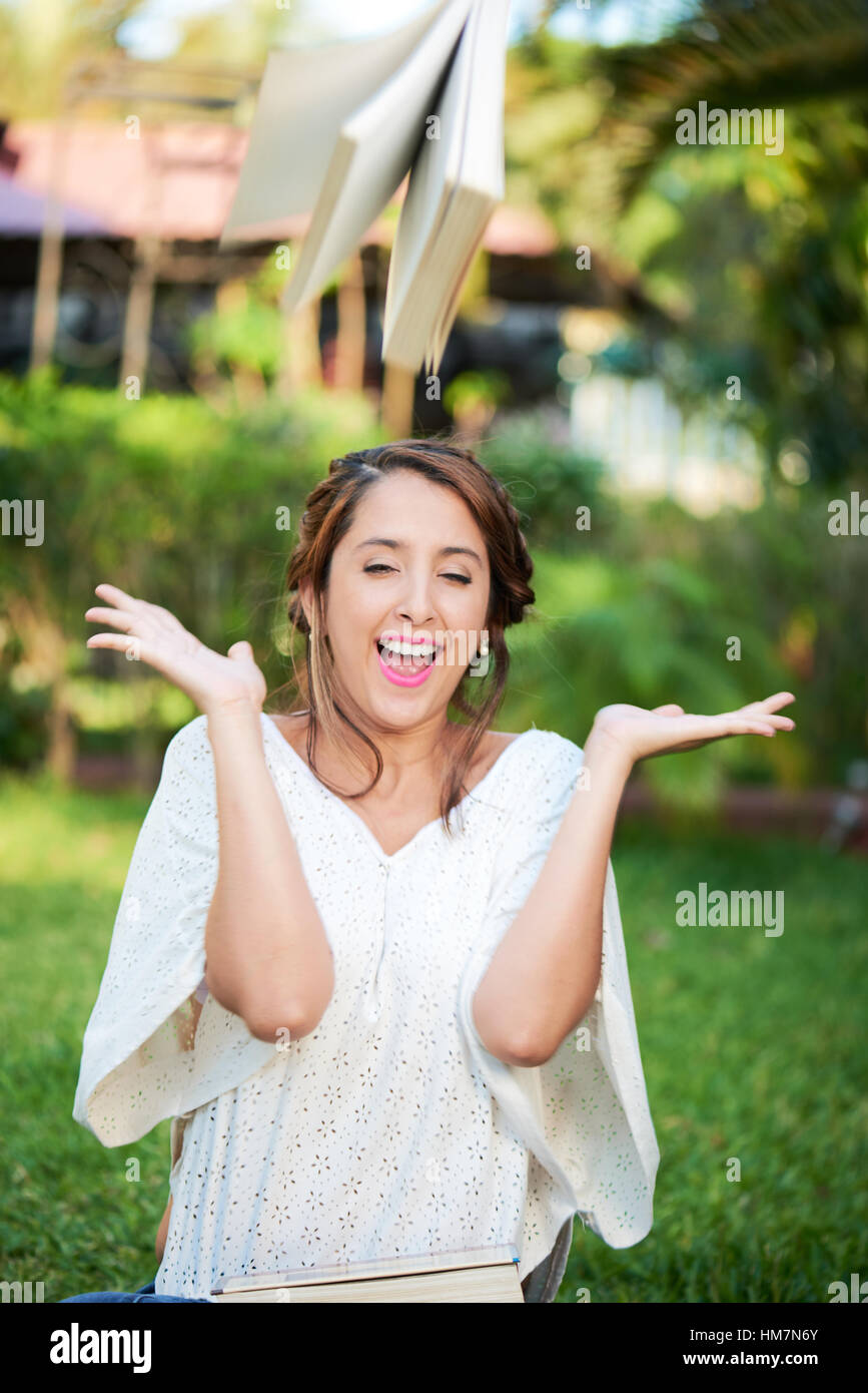 girl throwing a book in the air at a park Stock Photo - Alamy