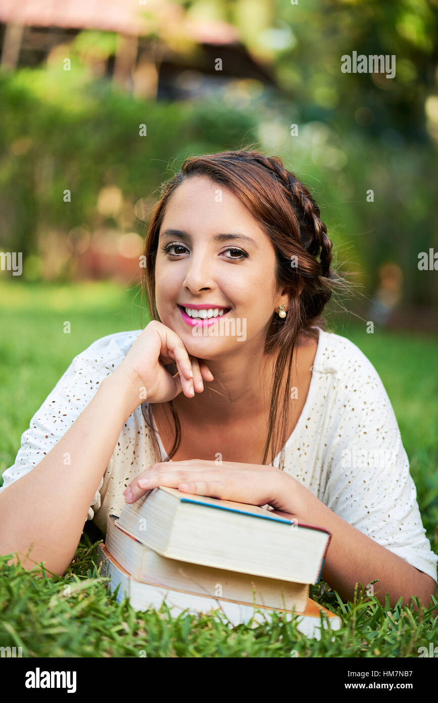 student girl with books lay on green grass Stock Photo - Alamy