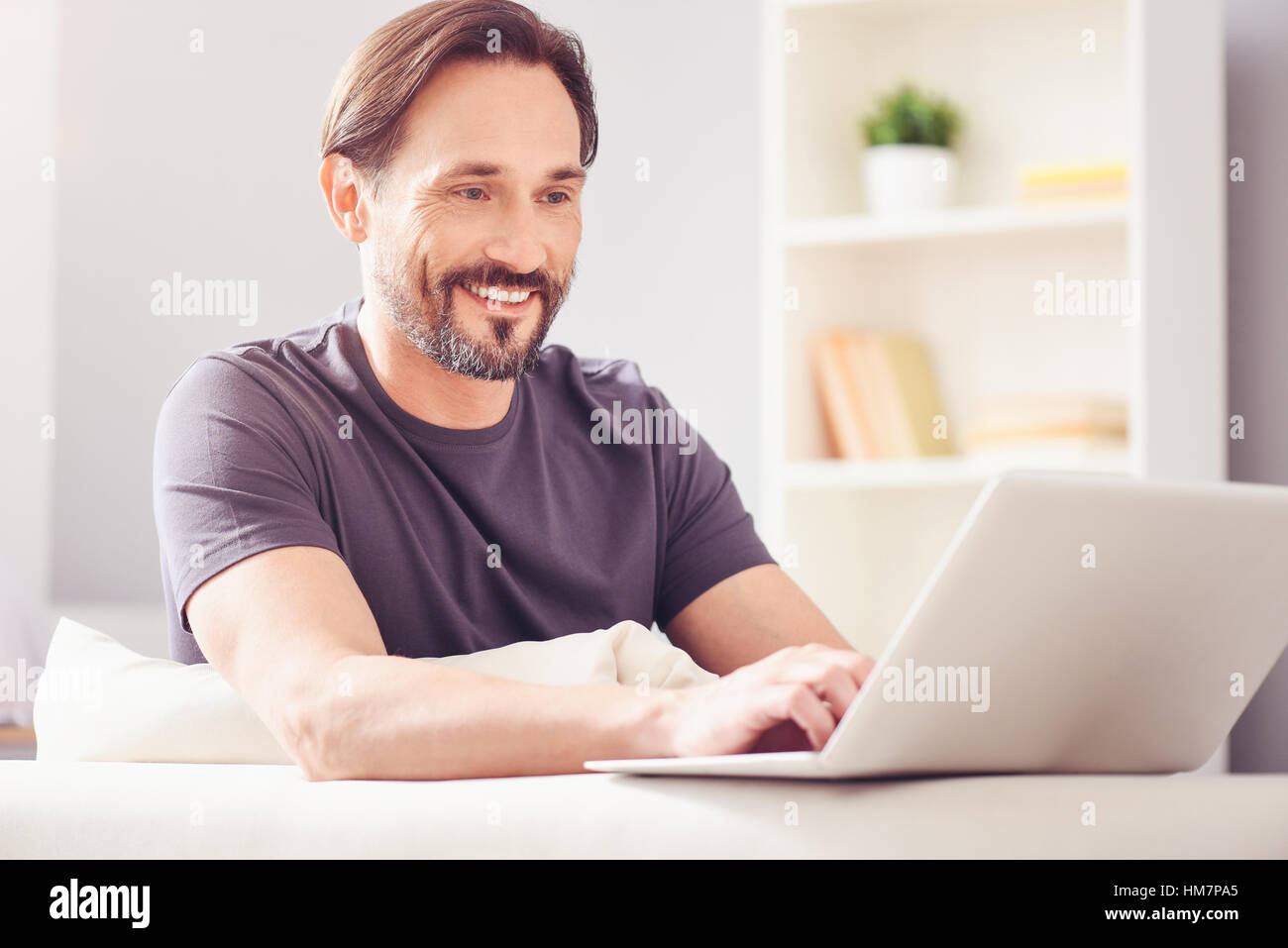 Cheerful smiling man sitting at the table Stock Photo - Alamy