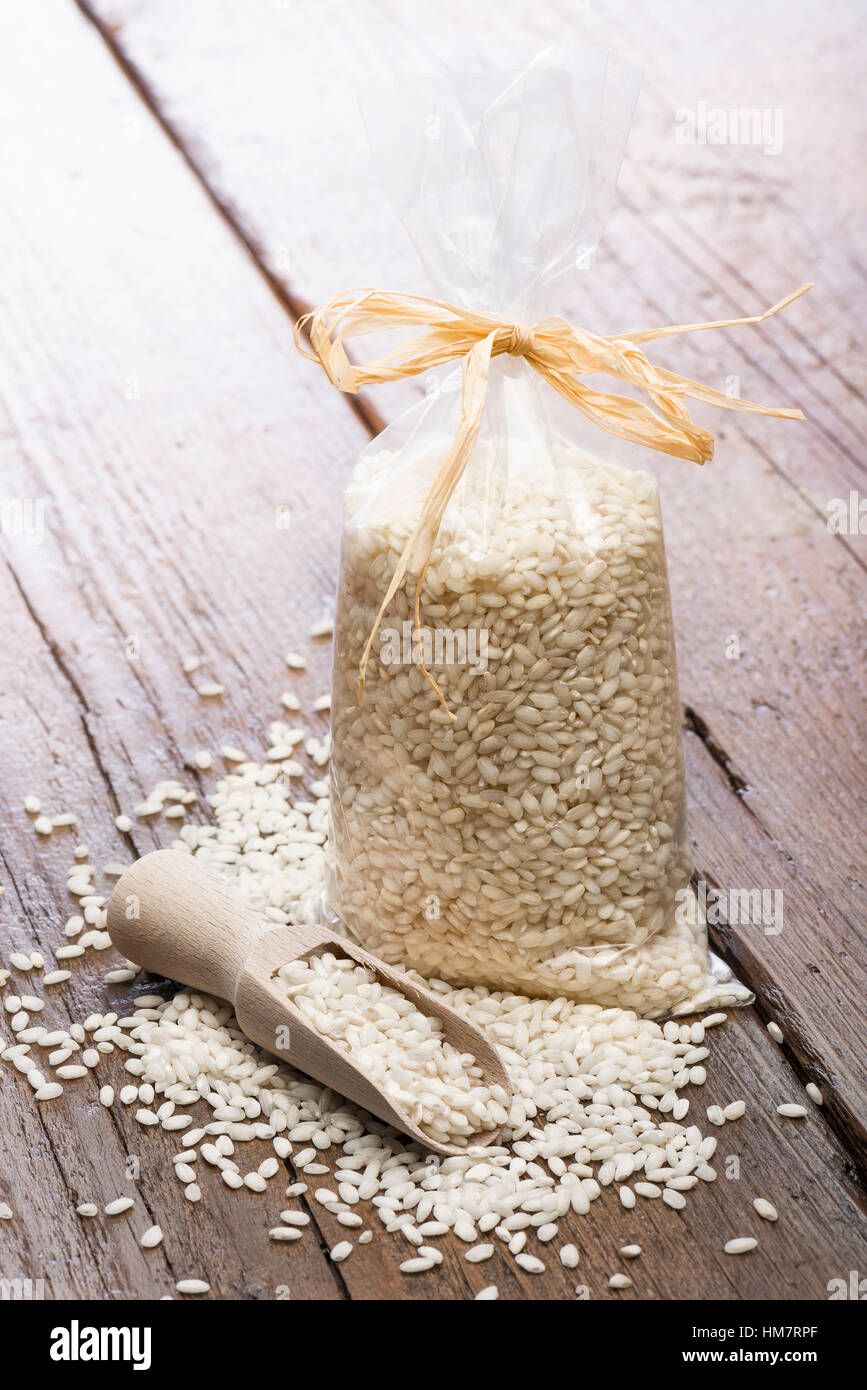 heap of white rice in transparent plastic bag with wooden scoop on ...