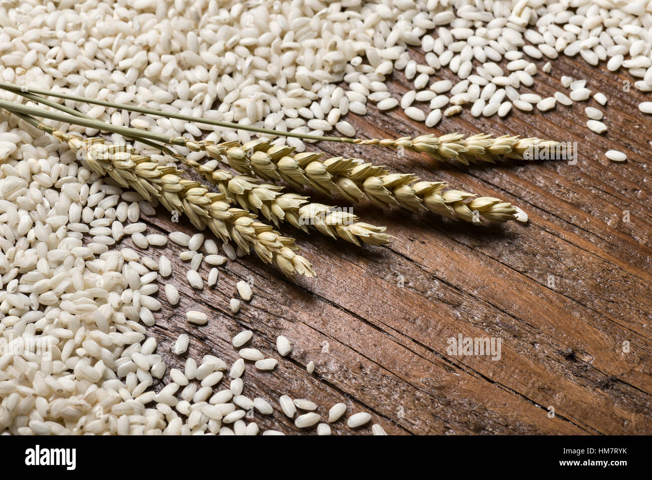 white rice scattered on wooden table with ears Stock Photo - Alamy