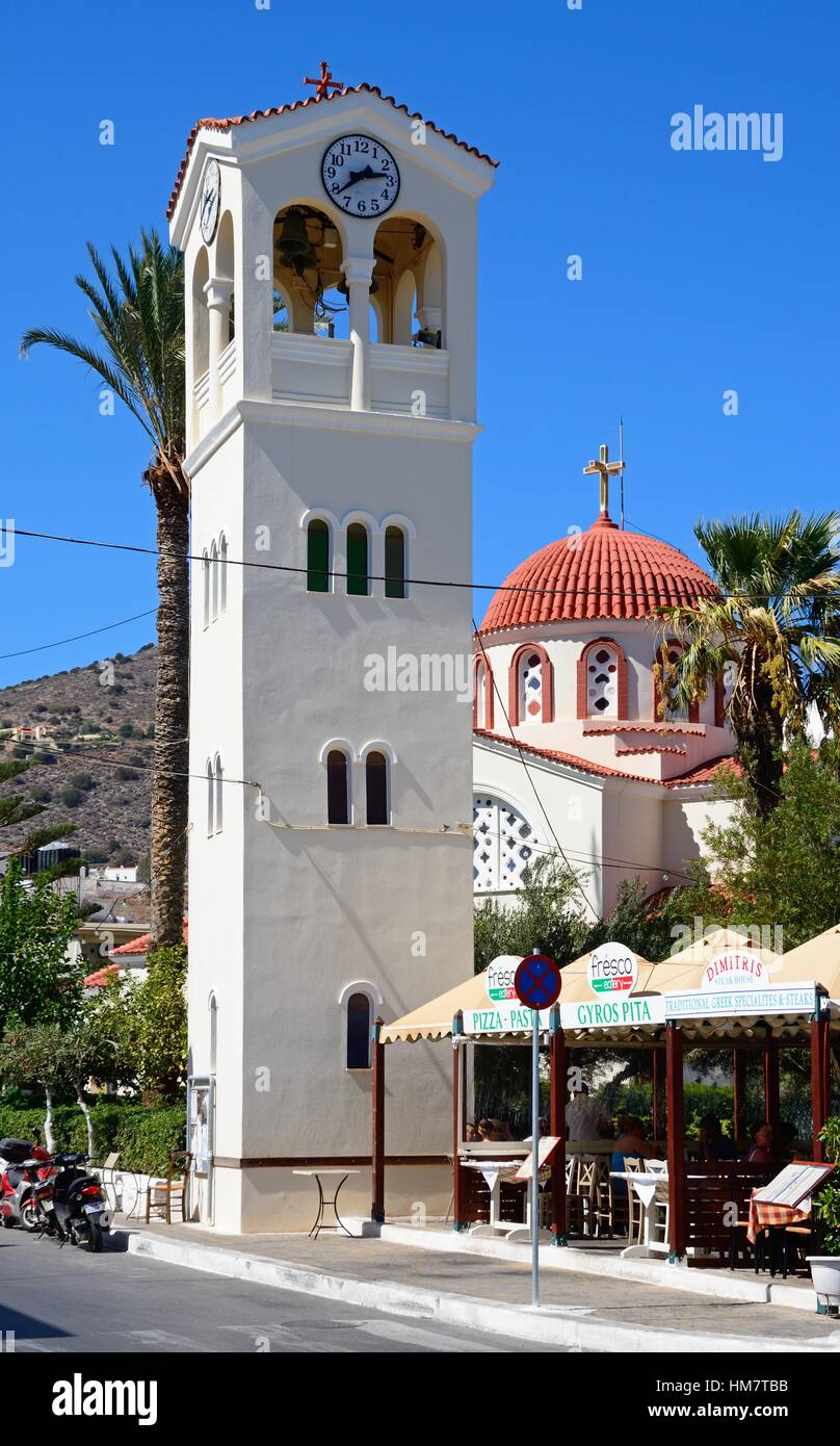 Clock tower with a Greek church to the rear in the town centre, Elounda ...