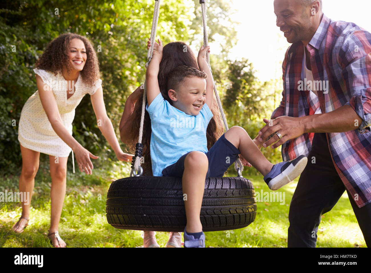 Boy pushing girl in swing hi-res stock photography and images - Alamy