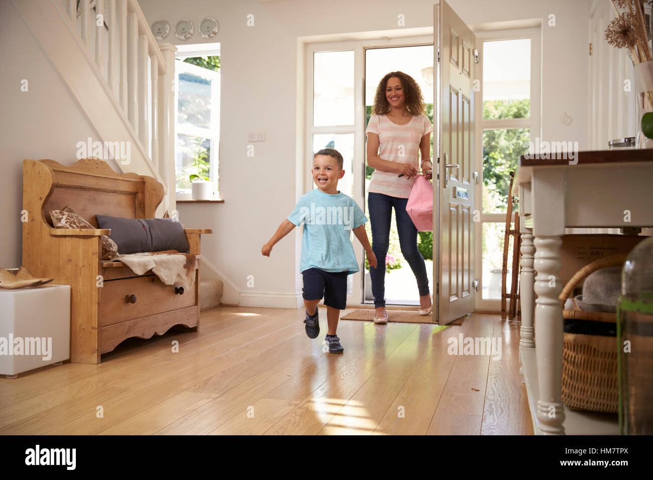 Excited Boy Returning Home From School With Mother Stock Photo - Alamy