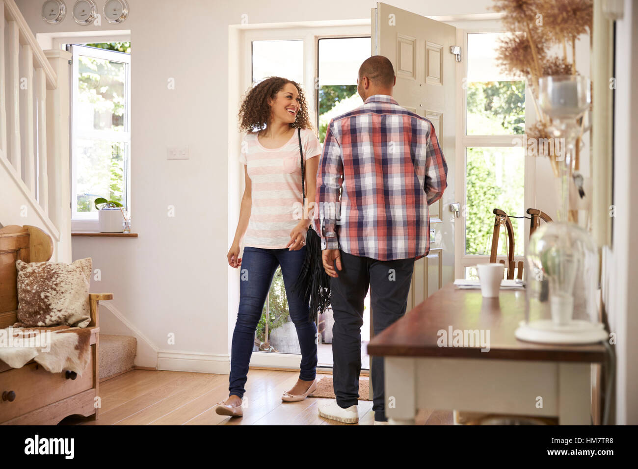 Man Opens Front Door For Woman Returning Home From Work Stock Photo - Alamy