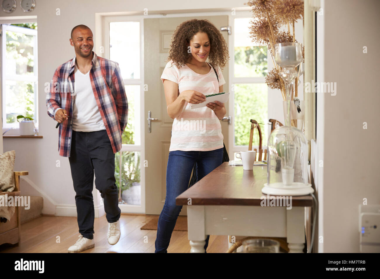 Couple In Hallway Returning Home Together Stock Photo - Alamy