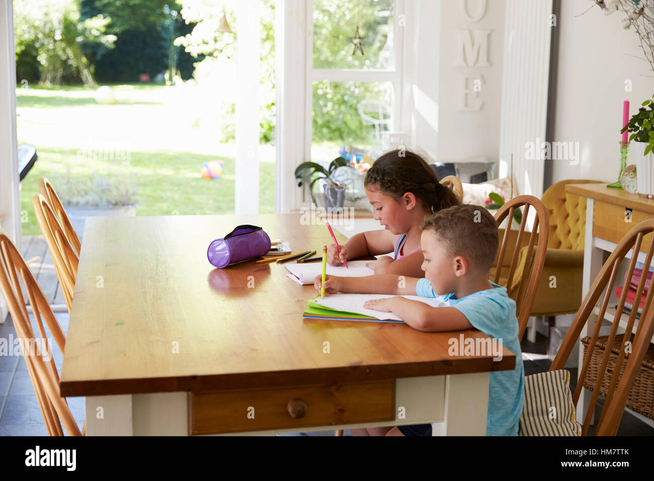 Brother And Sister Doing Homework At Table Stock Photo - Alamy