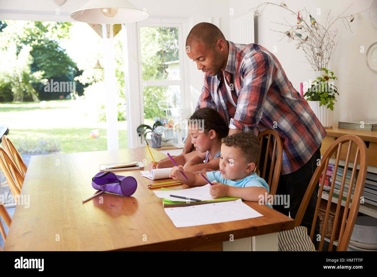 Father Helping Children With Homework At Table Stock Photo - Alamy