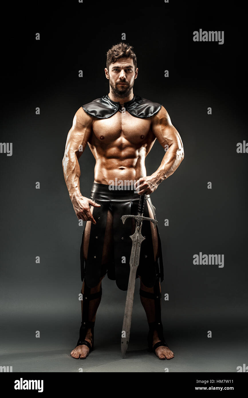 Severe barbarian in leather costume with sword Stock Photo - Alamy