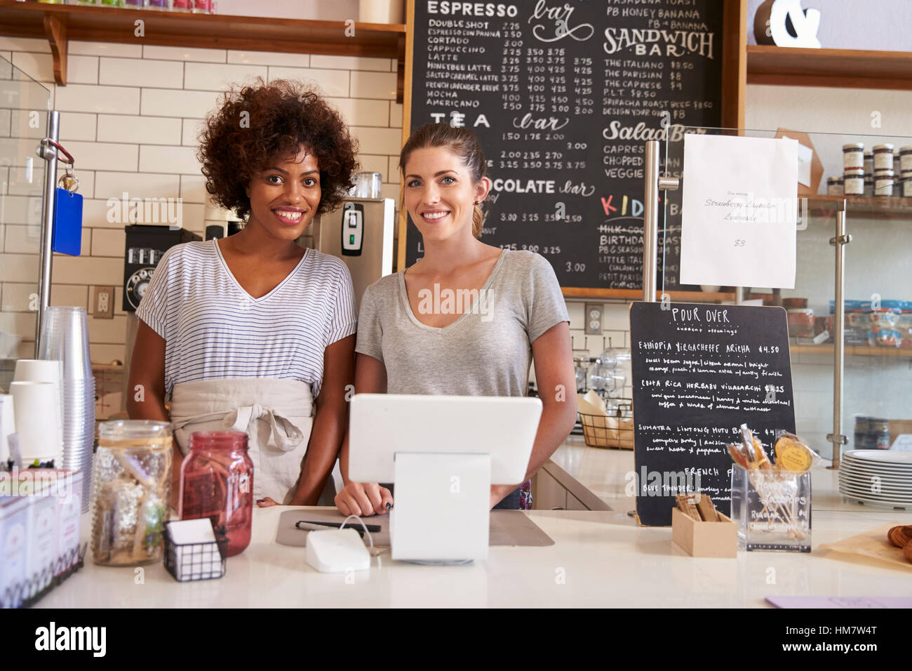 Two women behind the counter at a coffee shop, close up Stock Photo - Alamy