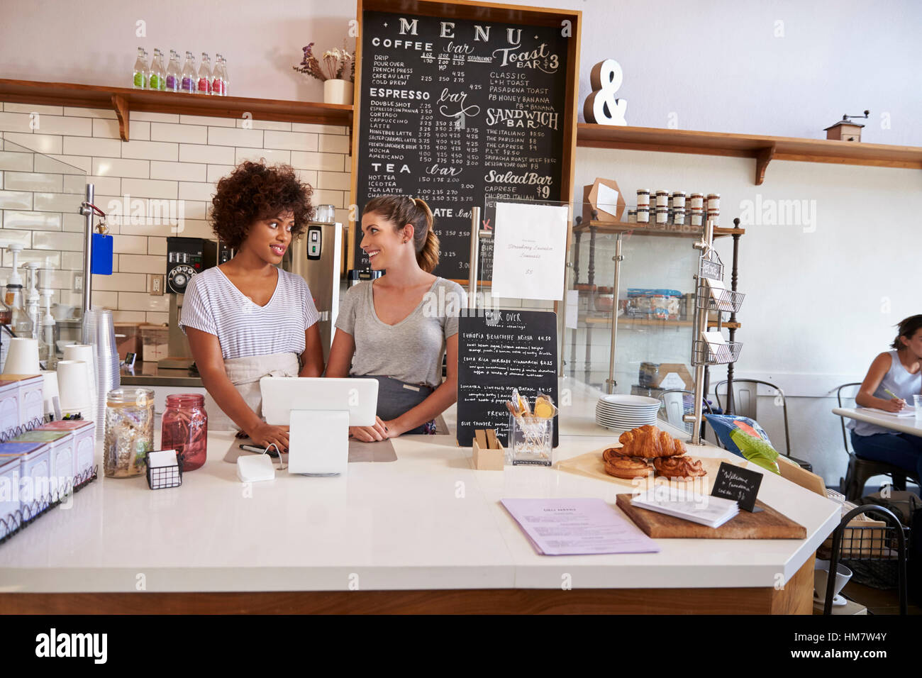 Two waitresses at a coffee shop looking at each other Stock Photo - Alamy