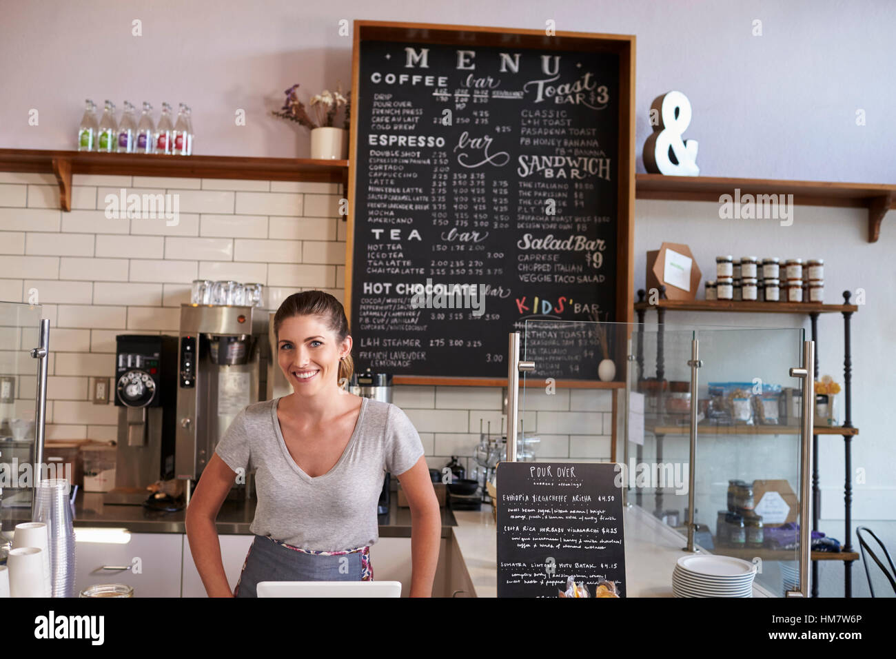 Woman behind the counter of a coffee shop looking to camera Stock Photo ...
